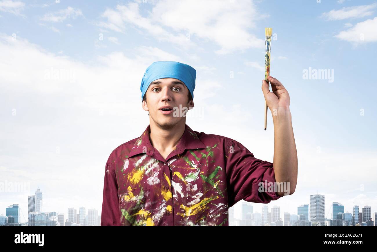 Handsome young painter artist pointing upwards Stock Photo - Alamy