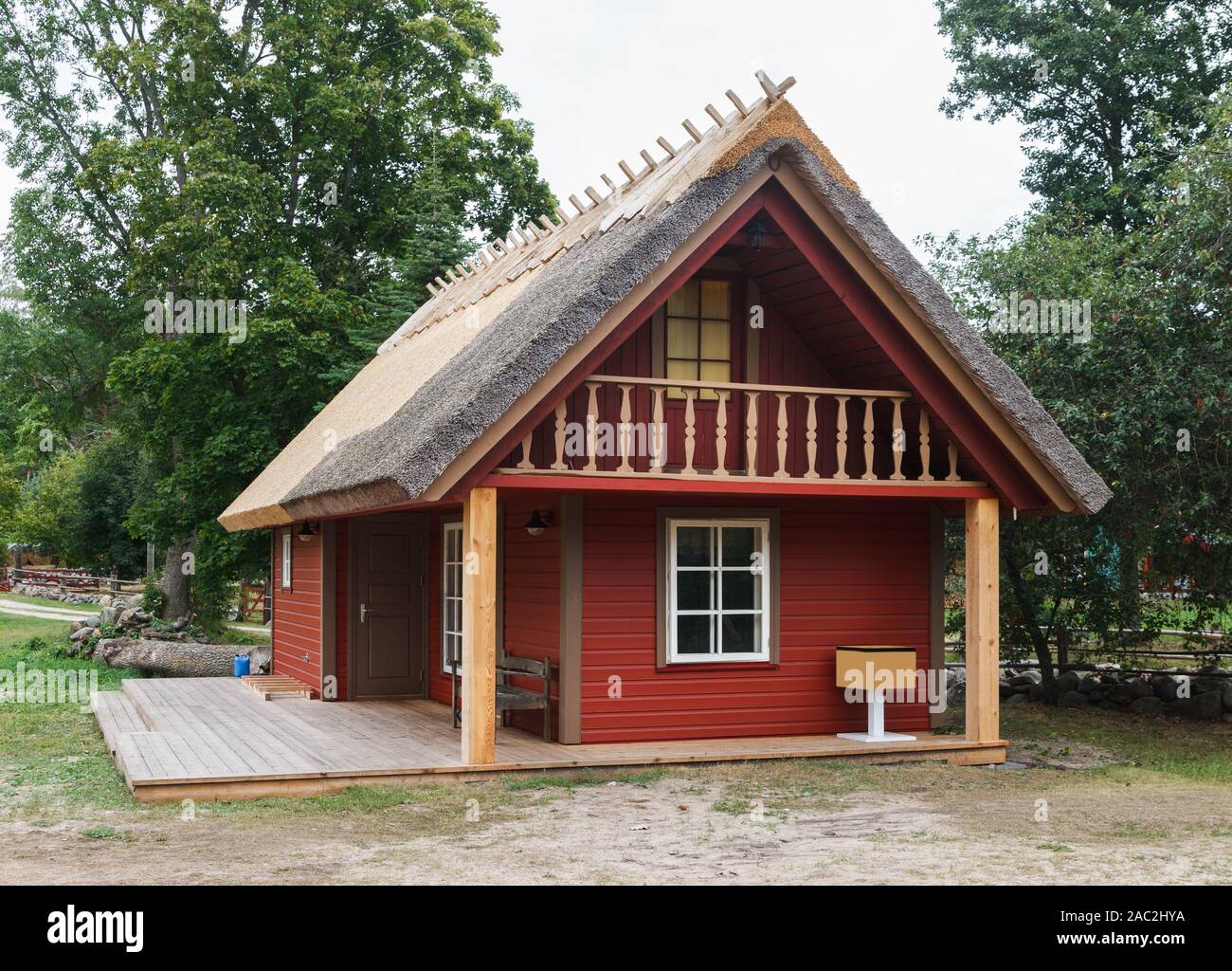 Small red wooden cottage with straw roof Stock Photo - Alamy