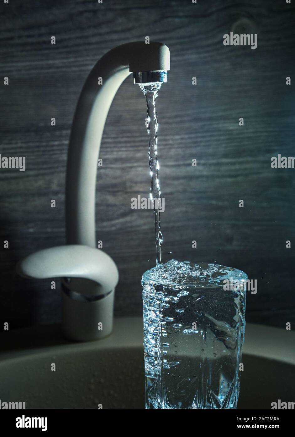Water running down in the glass from the tap Stock Photo - Alamy