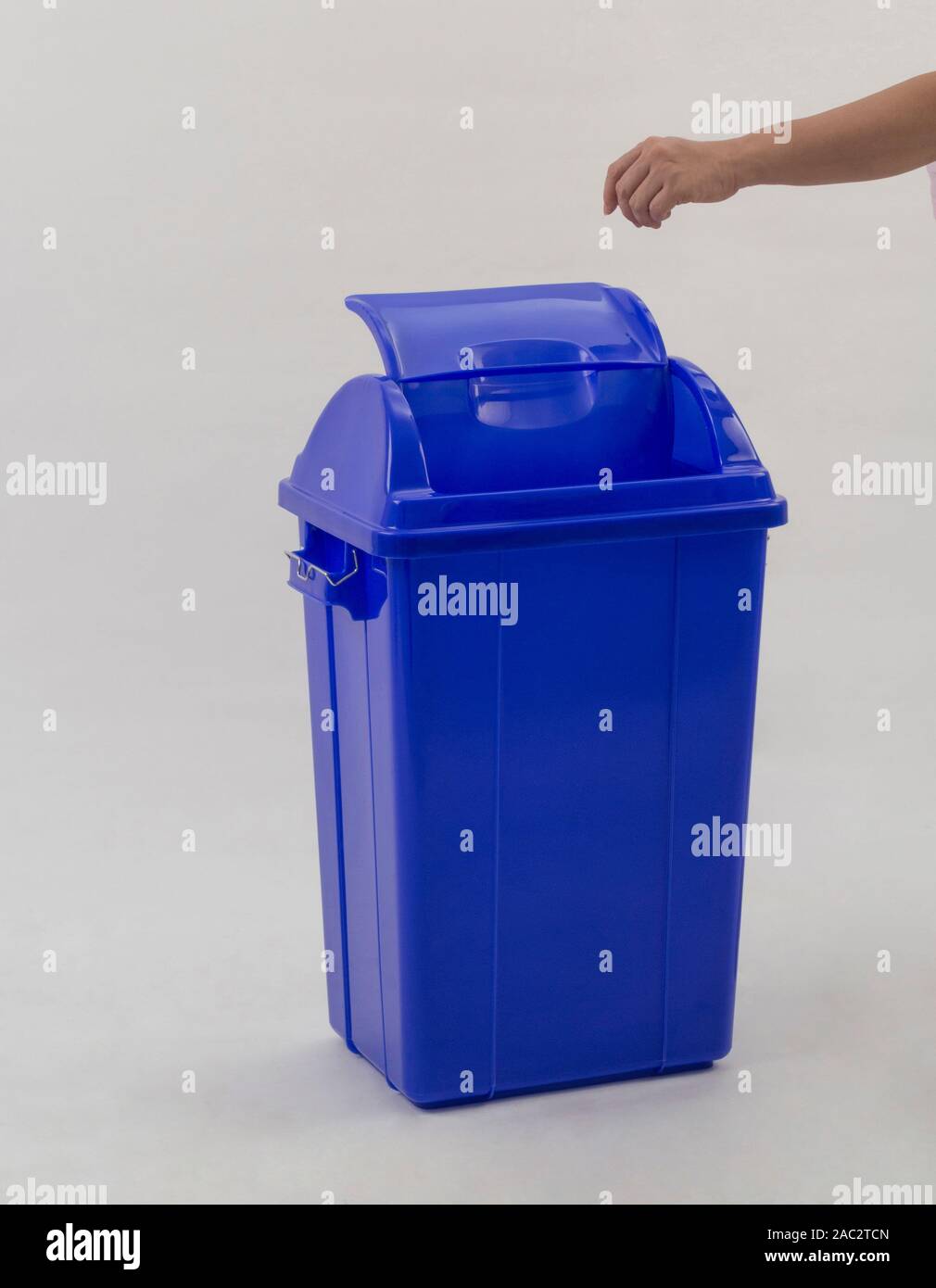 woman hand throwing something into the trash can isolated on white ...