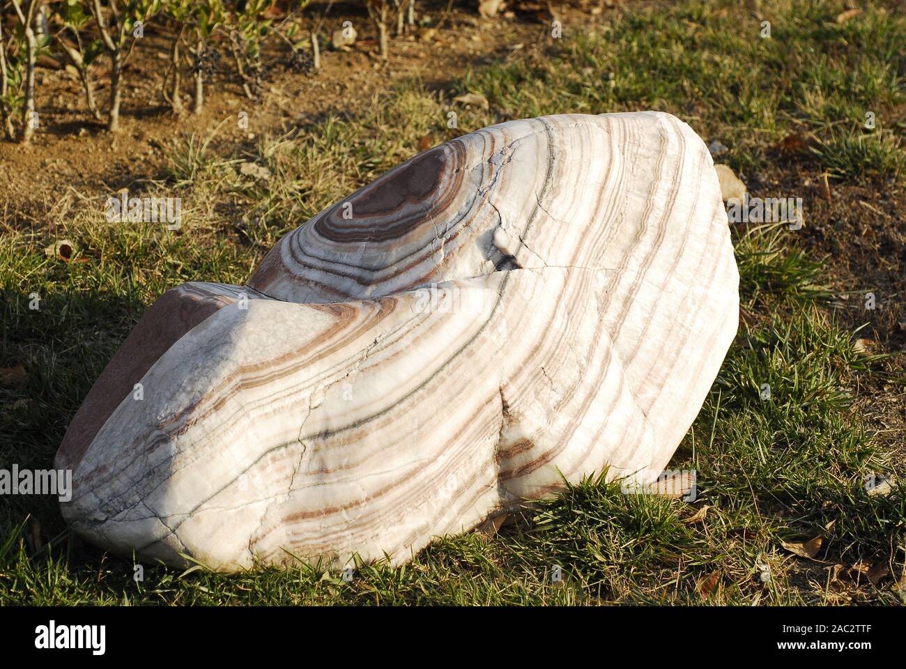 a white art rock with colorful water ripple Stock Photo - Alamy