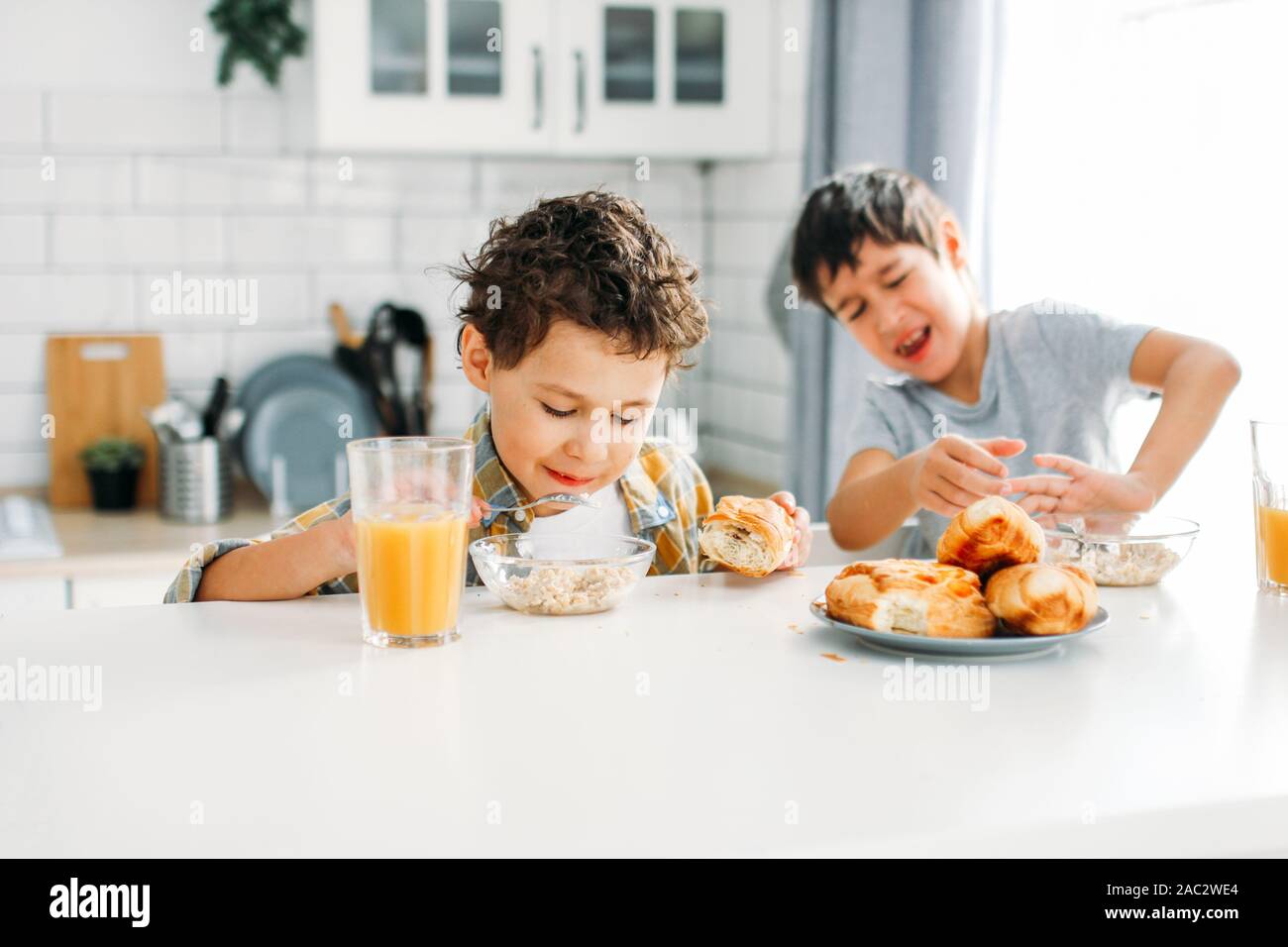 Two siblings tween boys real brothers having breakfast on bright ...