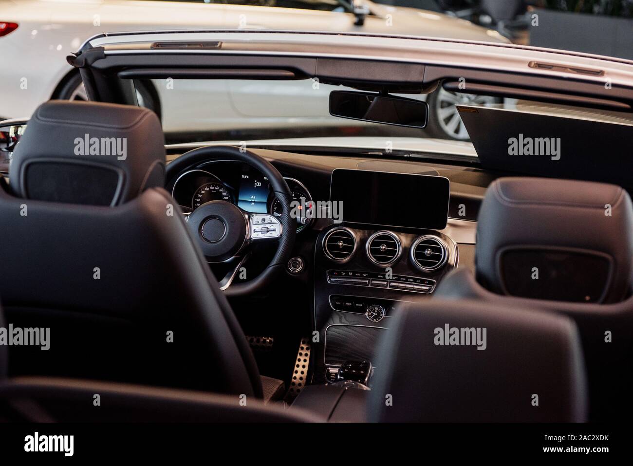 From the back seats. Inside of the modern car. Steering wheel and front ...