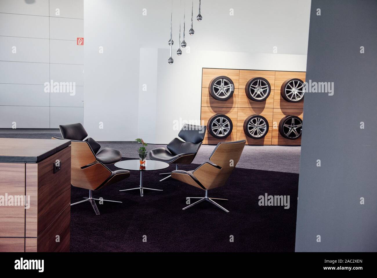 Spacious place. Interior of the car dealership with decorative wheels ...