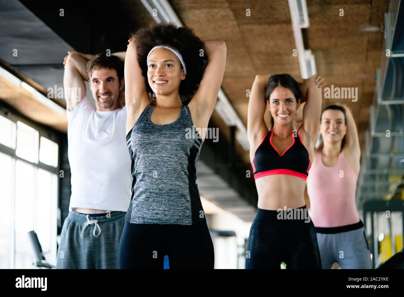 Beautiful fit people exercising together in gym Stock Photo - Alamy