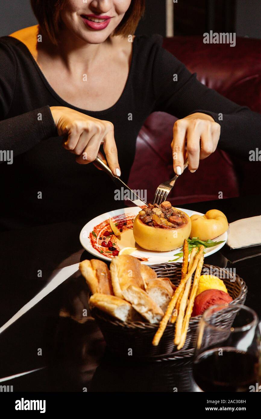 woman eating quince filled with meat Stock Photo - Alamy