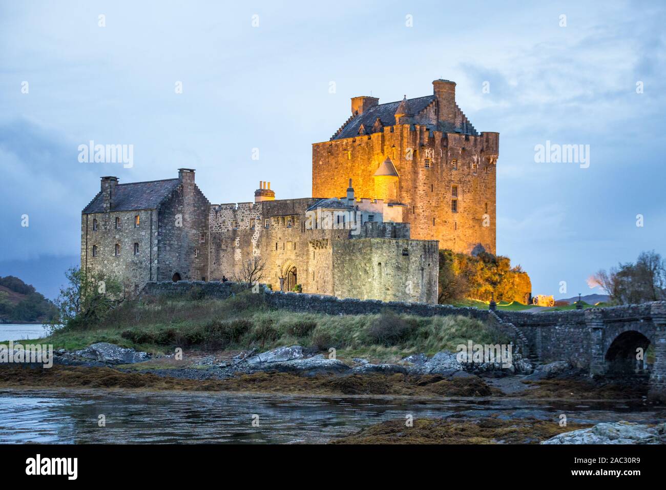 Beautiful old castle by the river in Scotland, foggy evening outside ...