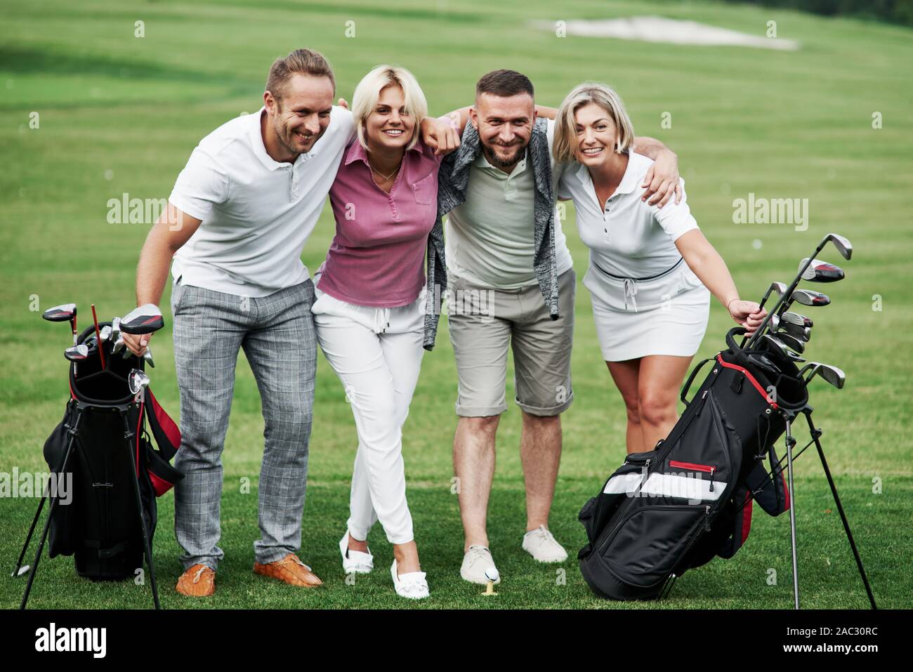 Photo of friends hugging and smiling with golf equipment after the game ...