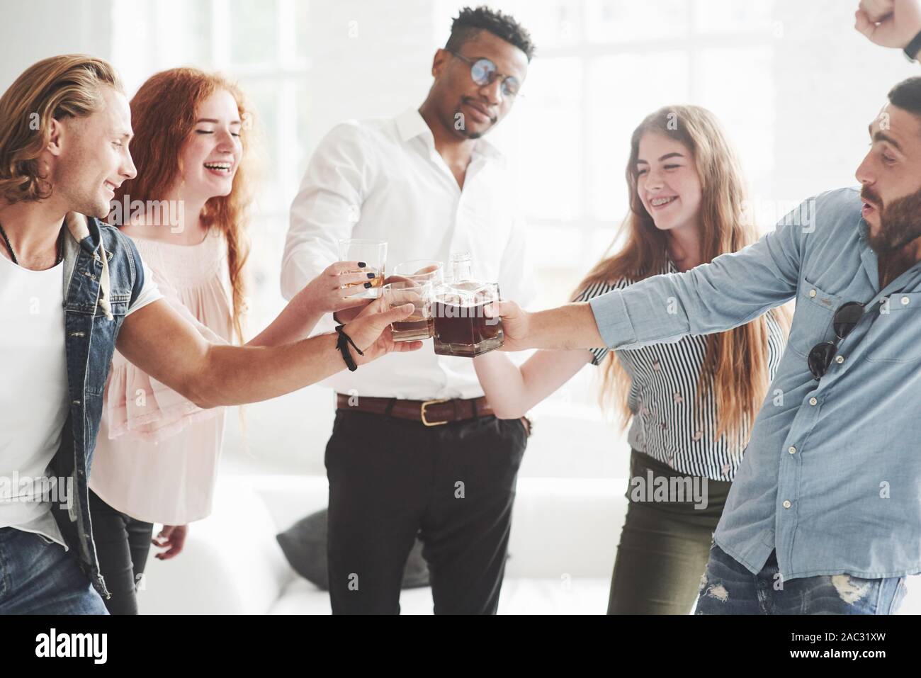 Let's have a drink. Five multiracial office workers celebrate their ...