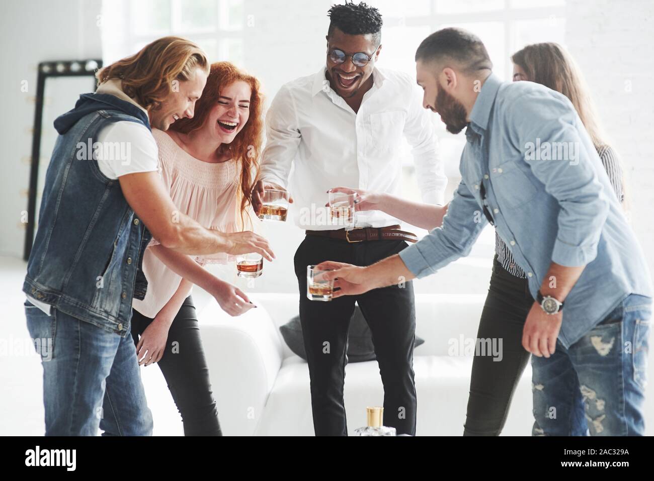 Celebration of team success. Teammates drinking whiskey and laughing ...