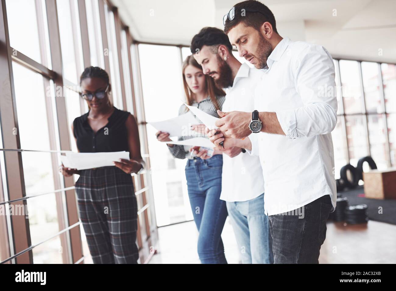 People reading documents in the office with big windows Stock Photo - Alamy