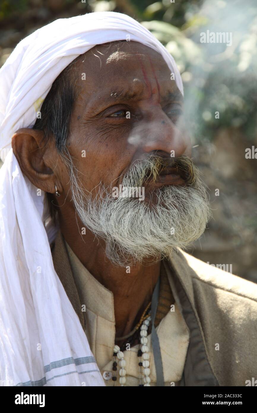 Indian man smokes a chillum pipe Stock Photo - Alamy