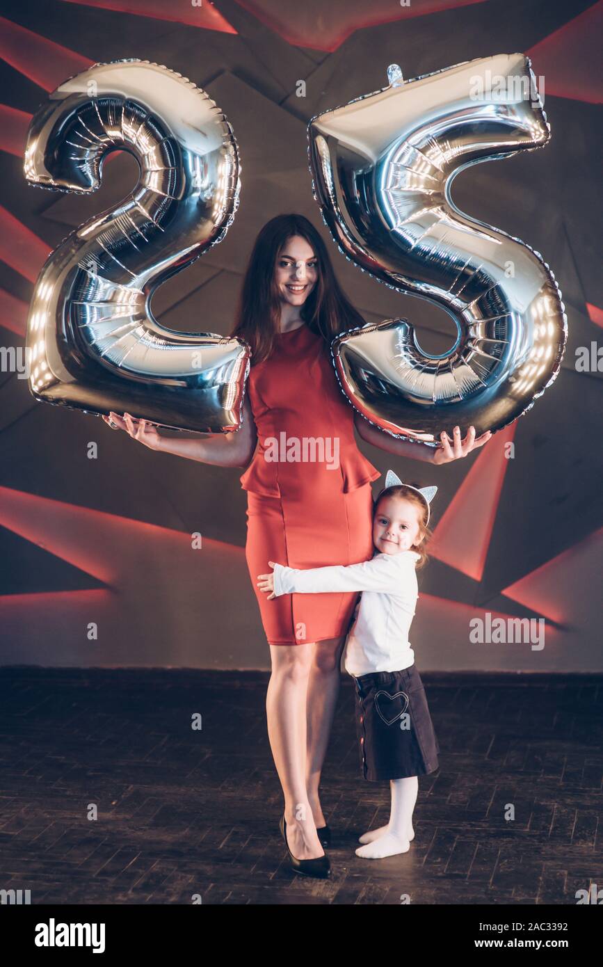 Beautiful woman holding the numbers with cute little girl what is ...