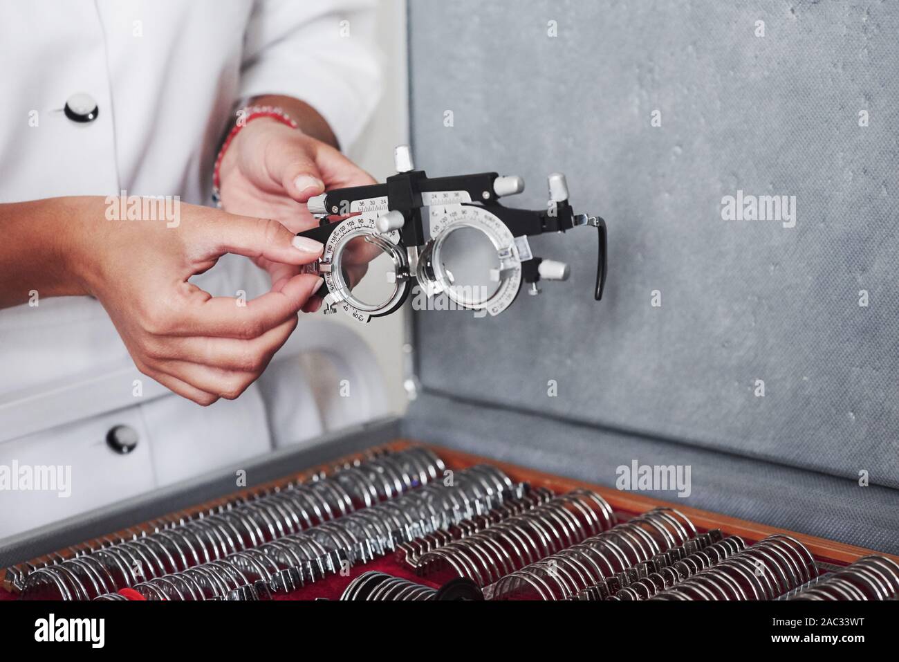 Many of different lenses below. Female hands holding the optical device ...