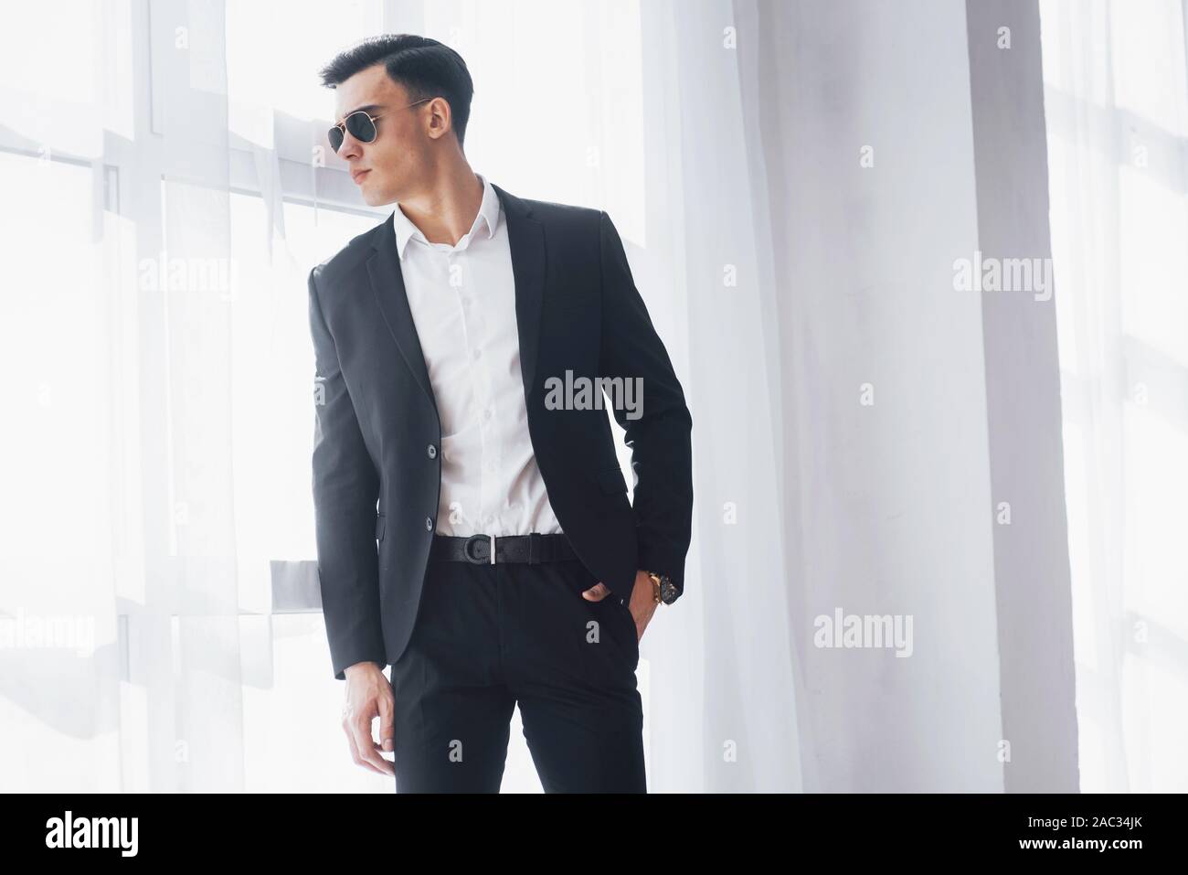 Side look. Portrait of young stylish man in classic business wear ...