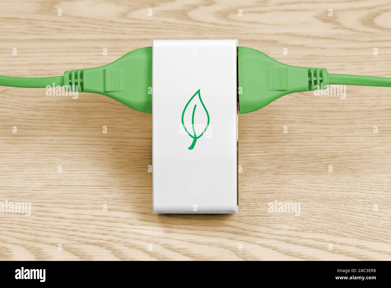 Two green cables connected to a multiple socket over a light wood ...