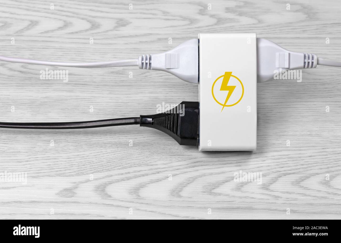 Two white cables and a black one connected to a multiple socket over a ...