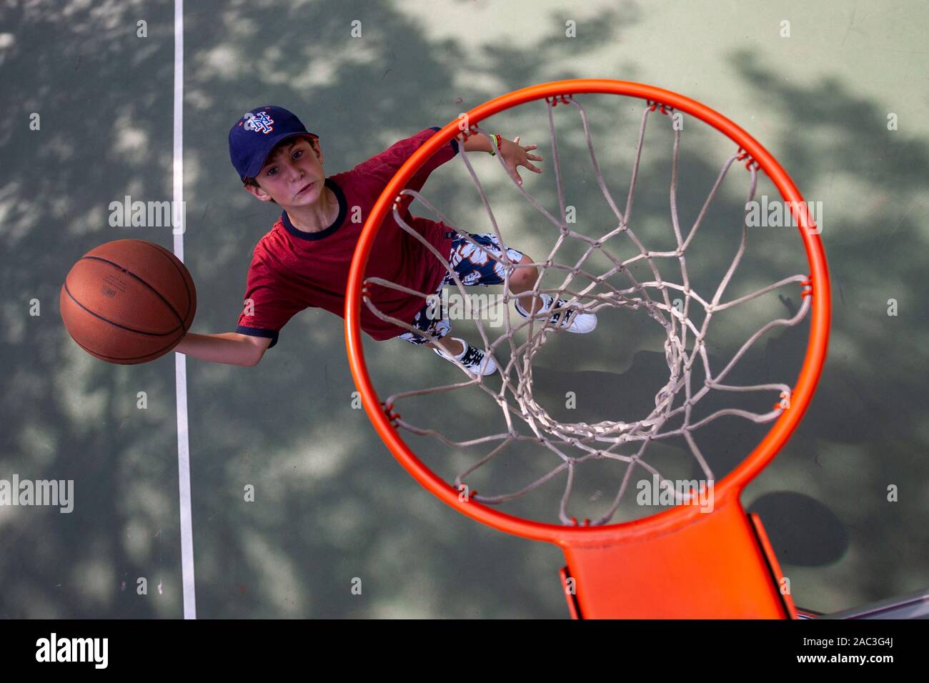 Boys dunking basketball at day camp Stock Photo - Alamy