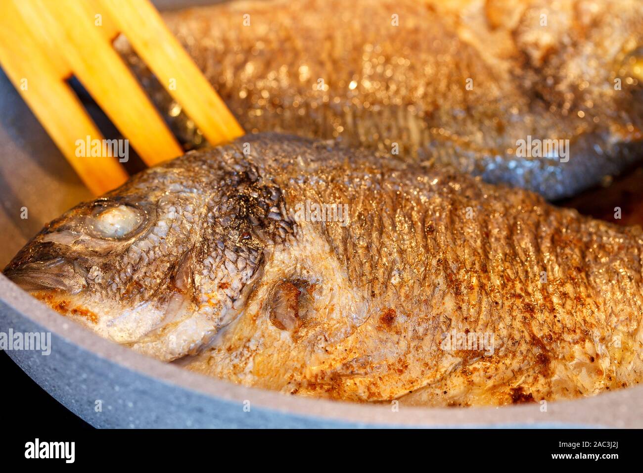 Fried Dorado fish in a frying pan. Close-up Stock Photo - Alamy