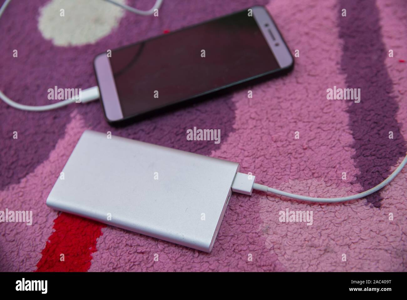 Smartphone Charging with silver Power Bank Through Spiral USB Cable ...