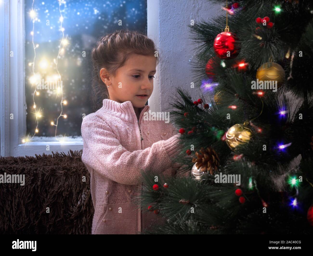 A child dresses up a Christmas tree Stock Photo - Alamy