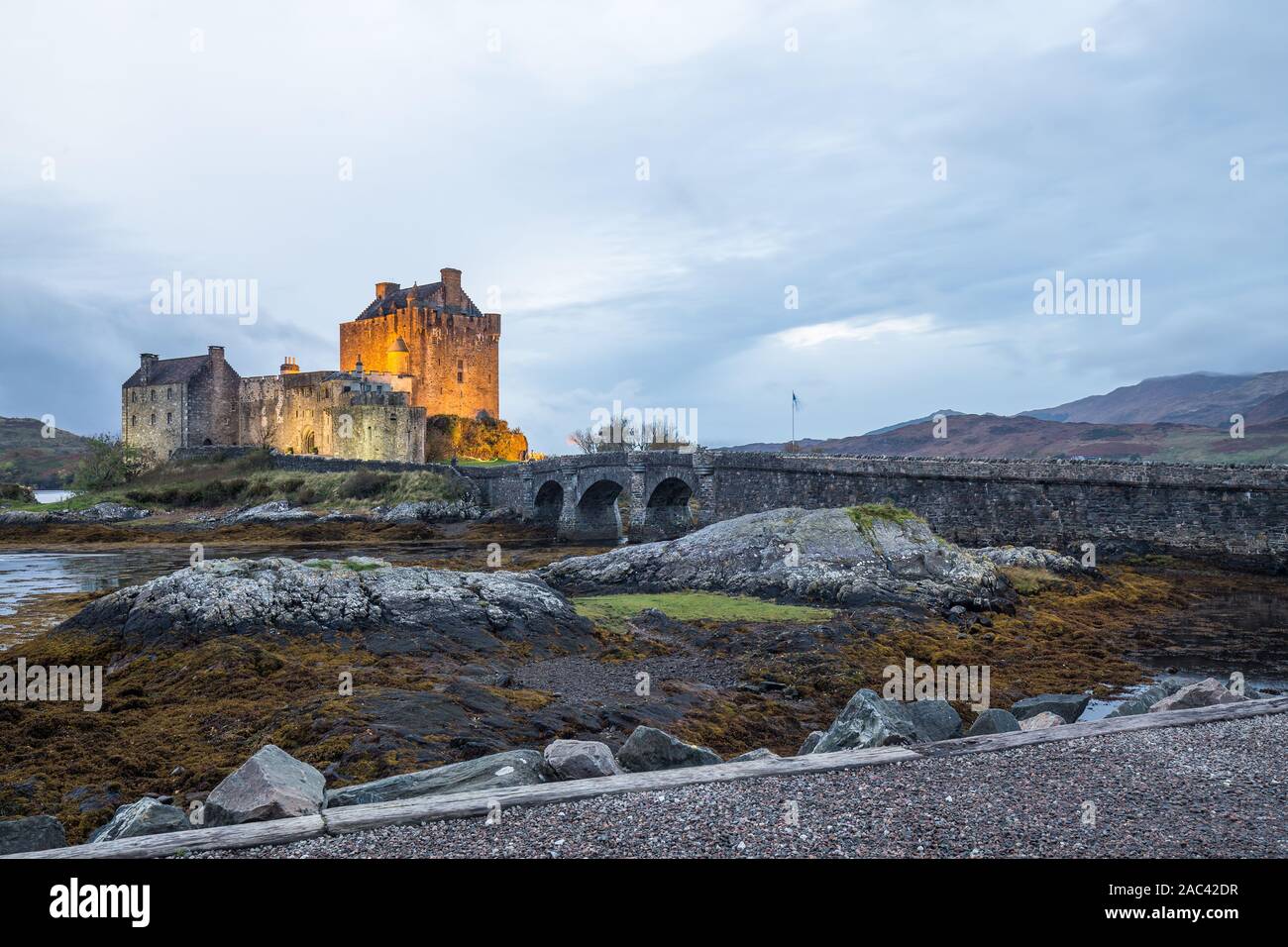 Beautiful old castle by the river in Scotland, foggy evening outside ...