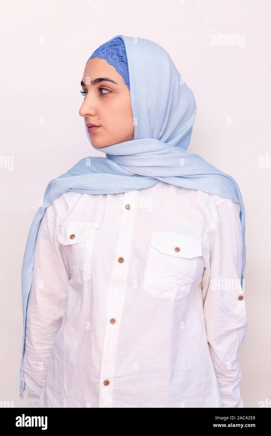 Elegant Muslim woman in a white shirt and bright blue hijab. Stylish ...
