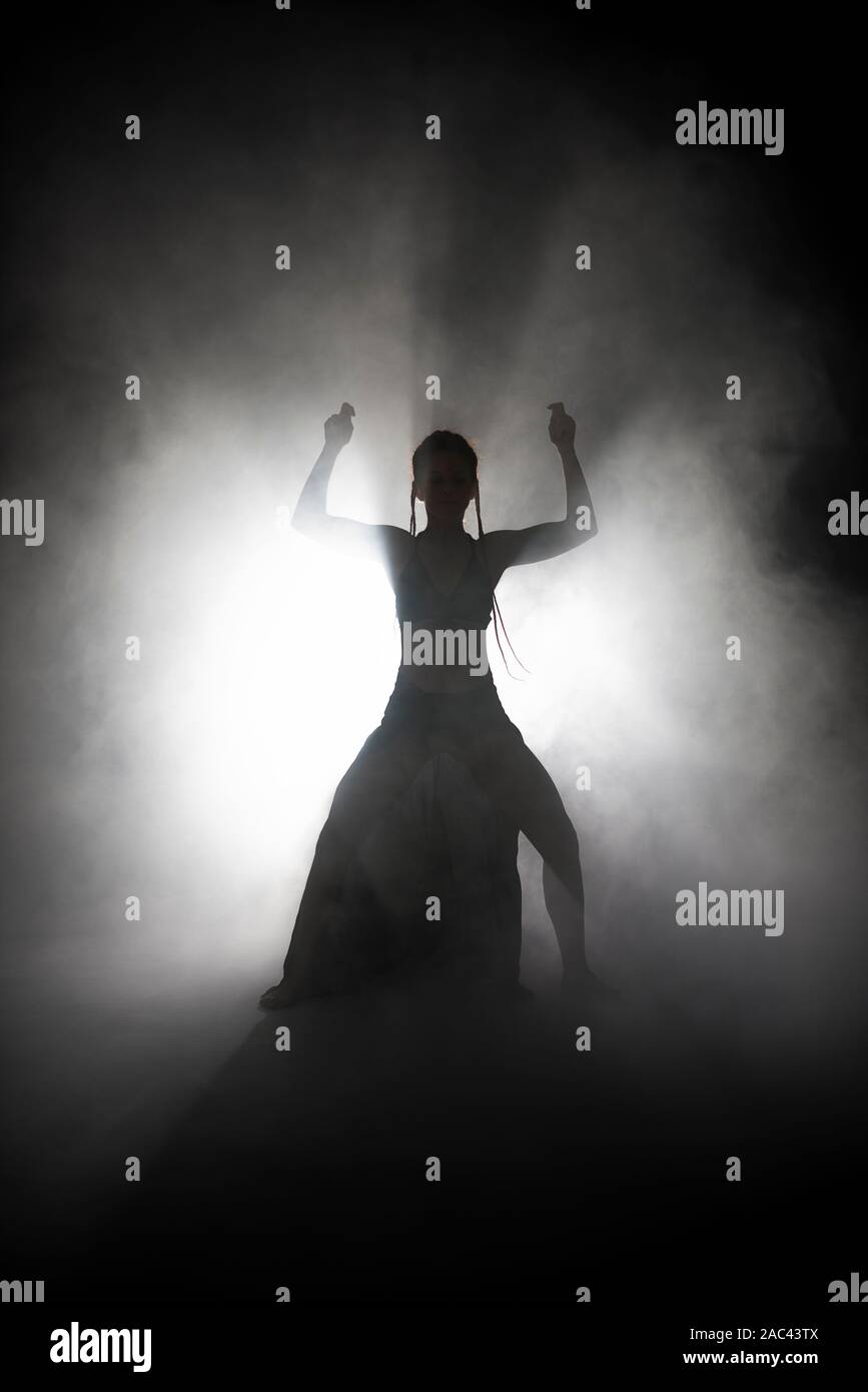 Silhouette dancer woman performing dance figures in fog Stock Photo - Alamy