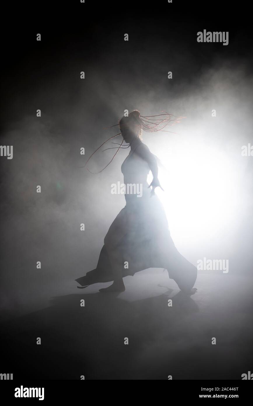 Silhouette dancer woman performing dance figures in fog Stock Photo - Alamy