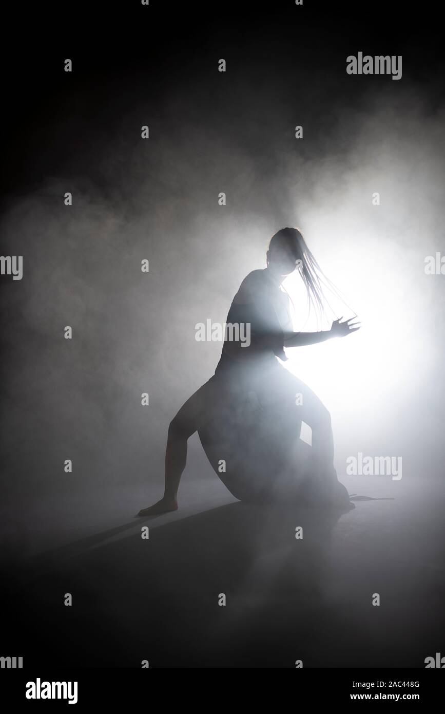 Silhouette dancer woman performing dance figures in fog Stock Photo - Alamy