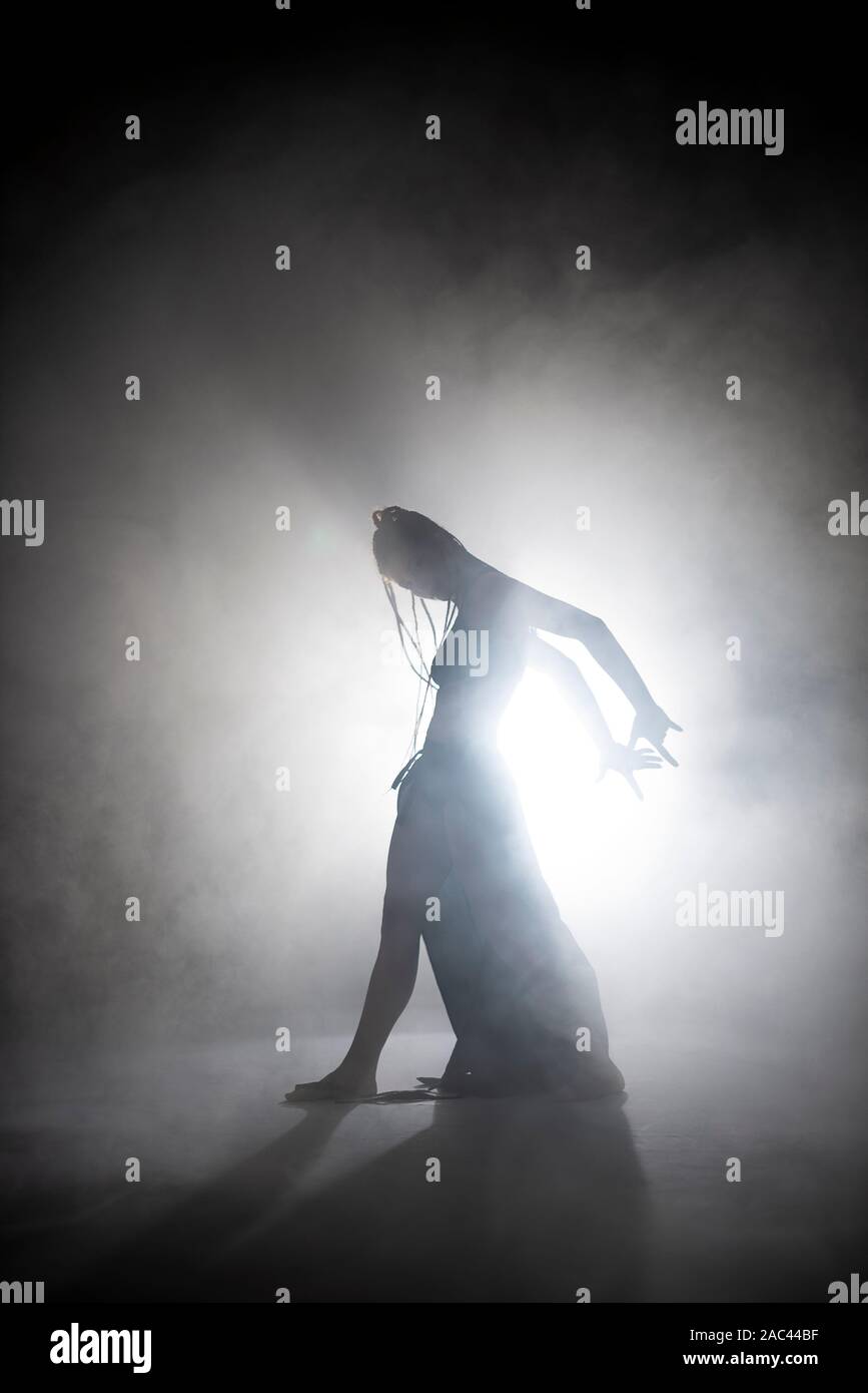 Silhouette dancer woman performing dance figures in fog Stock Photo - Alamy