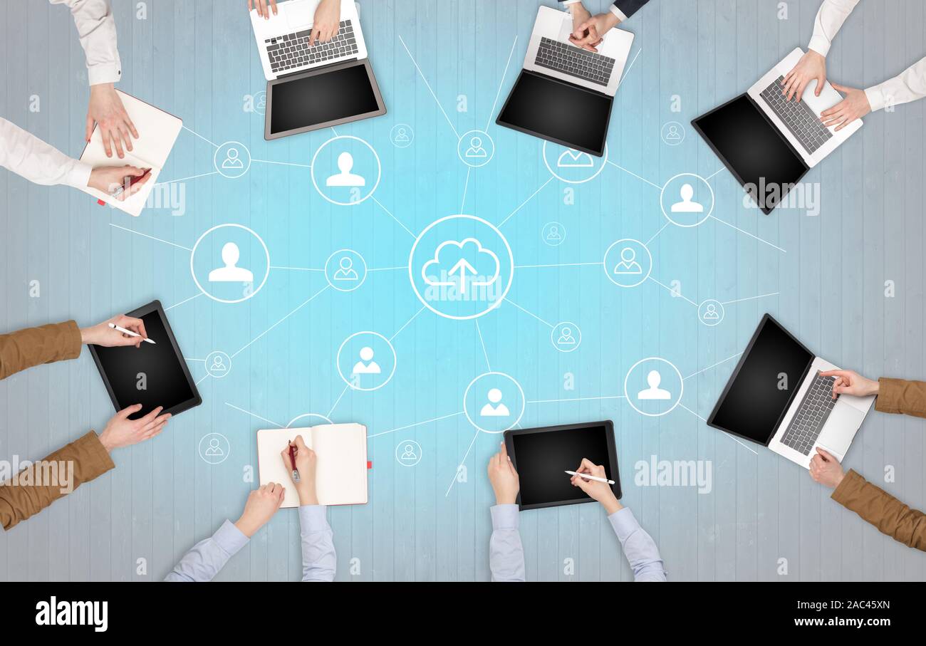 Group of people with devices in hands working in team on tablets ...