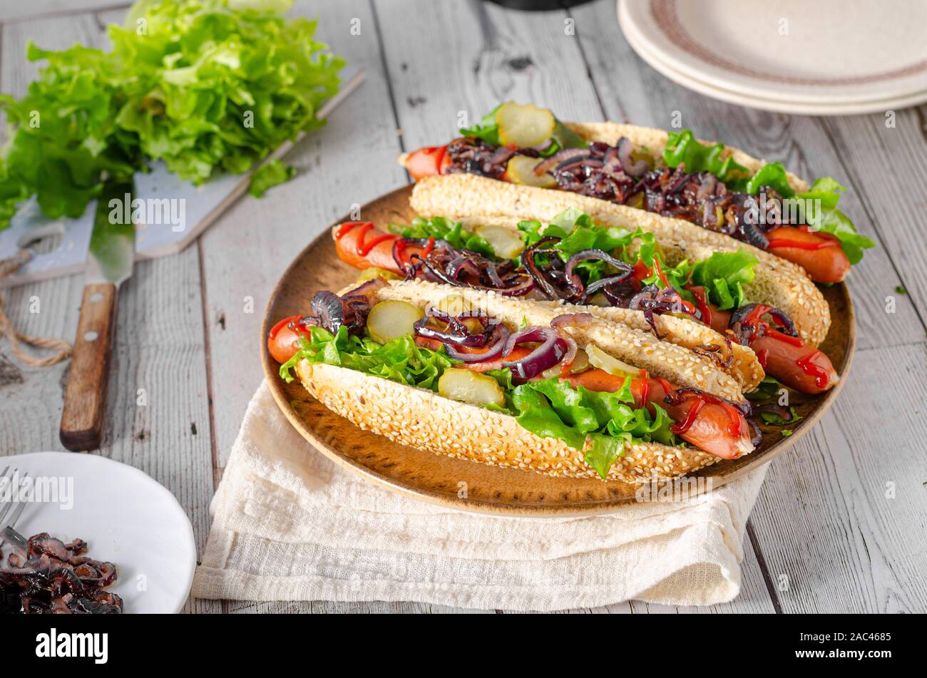 Hot dog with red onion, pickles and fresh salad Stock Photo - Alamy