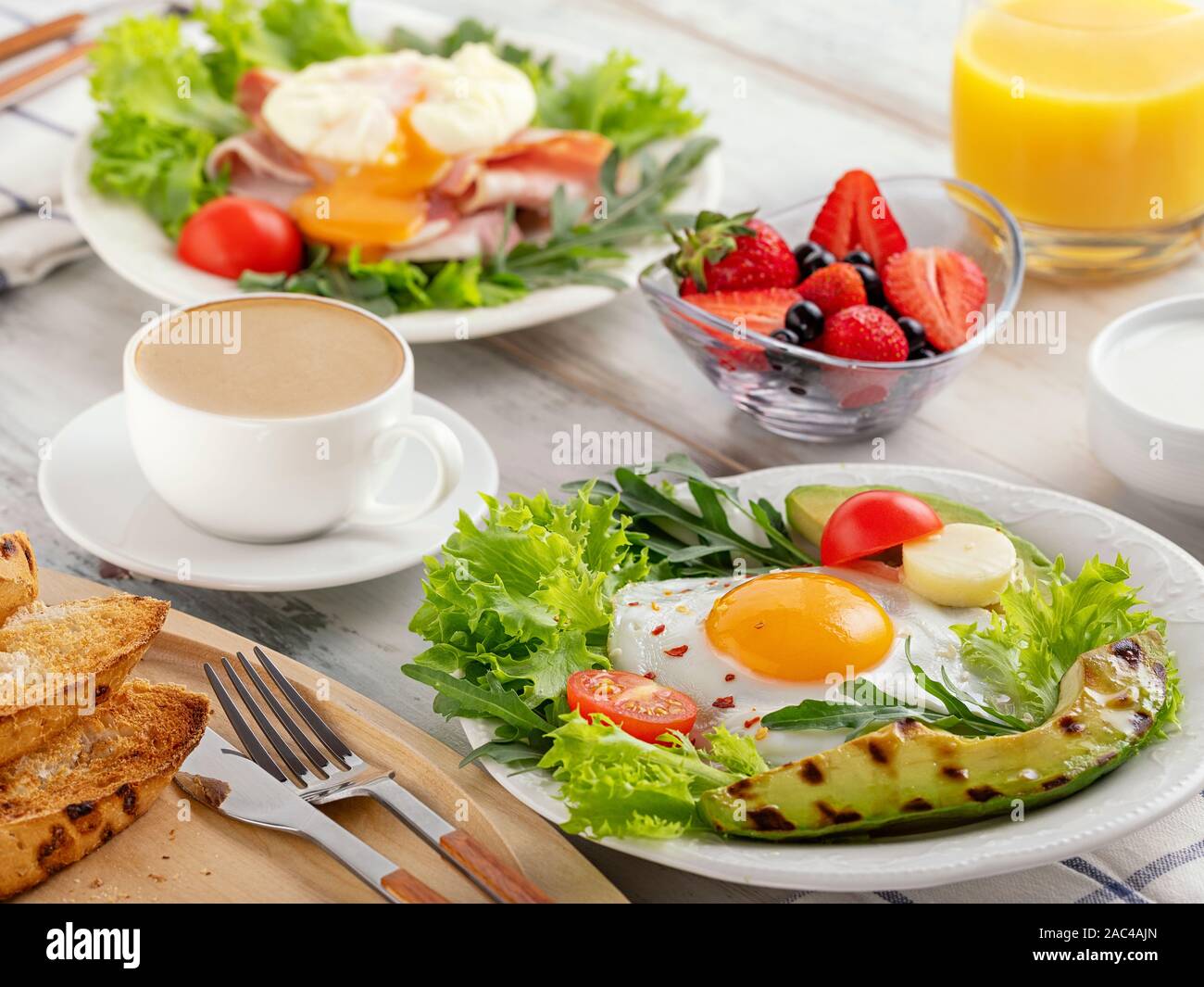 Healthy breakfast with fried eggs, avocado, tomato, toasts and coffee ...