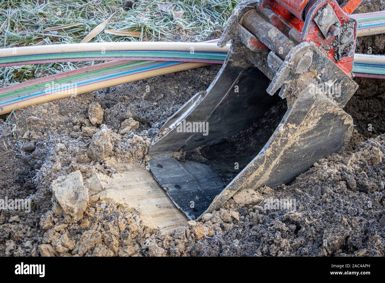 an excavator digging a trench to lay a high-speed Internet DSL cable ...