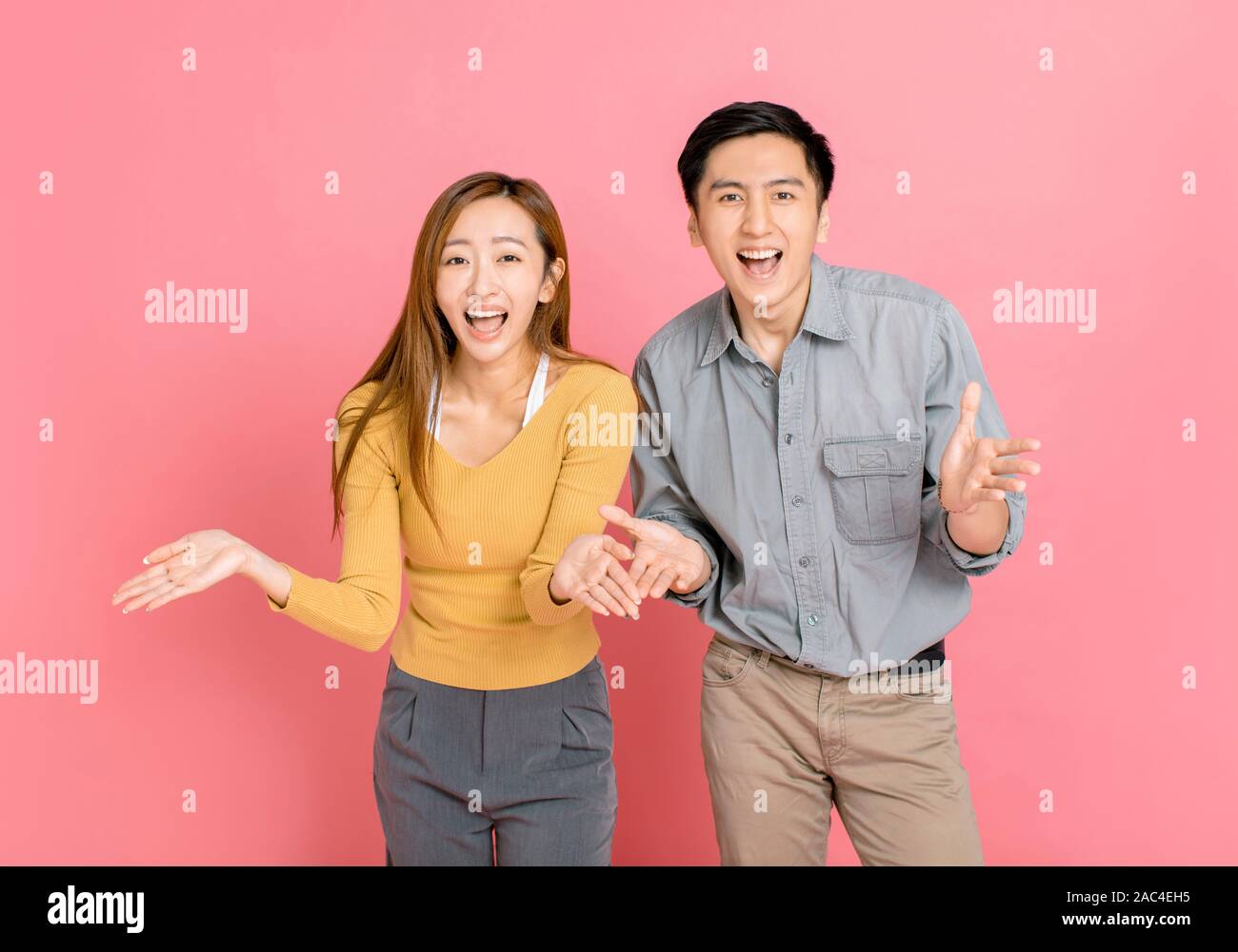 Happy young couple with arms up celebrating Stock Photo - Alamy