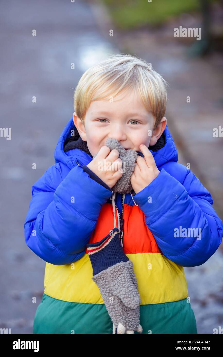 Hide and seek The boy is playing outside in outdoor clothing he is ...