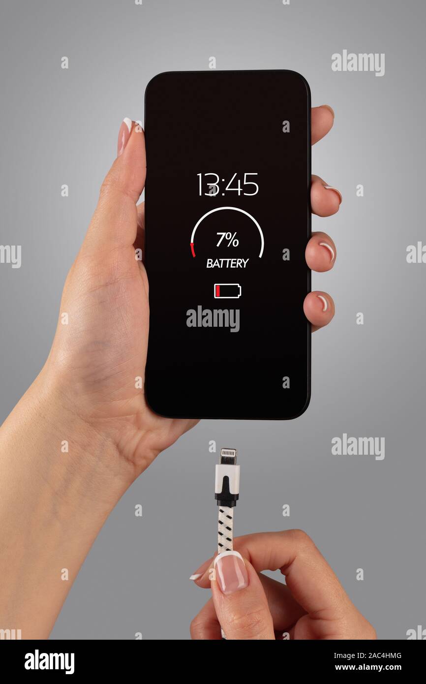 Elegant hand charging cellphone with low battery Stock Photo - Alamy