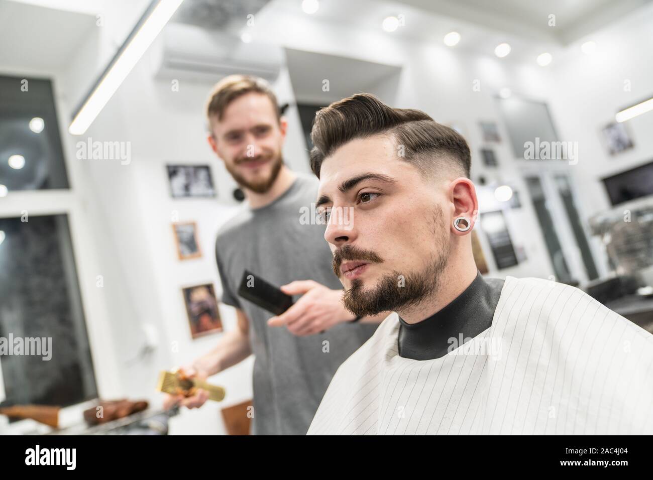 Customer smiling in barber shop with barber. Fun barber Stock Photo - Alamy