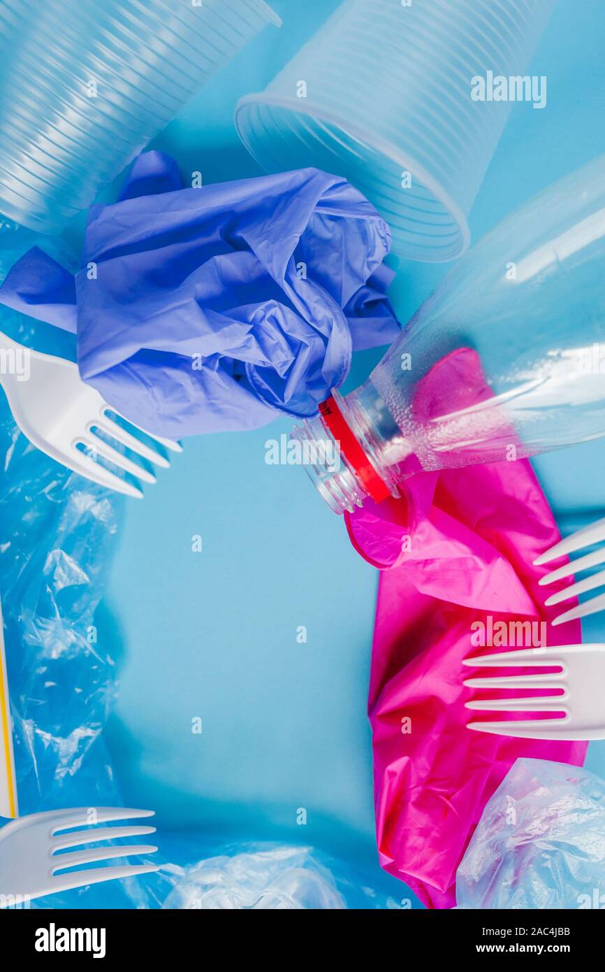 Top view of various kinds of disposable plastic waste on blue ...