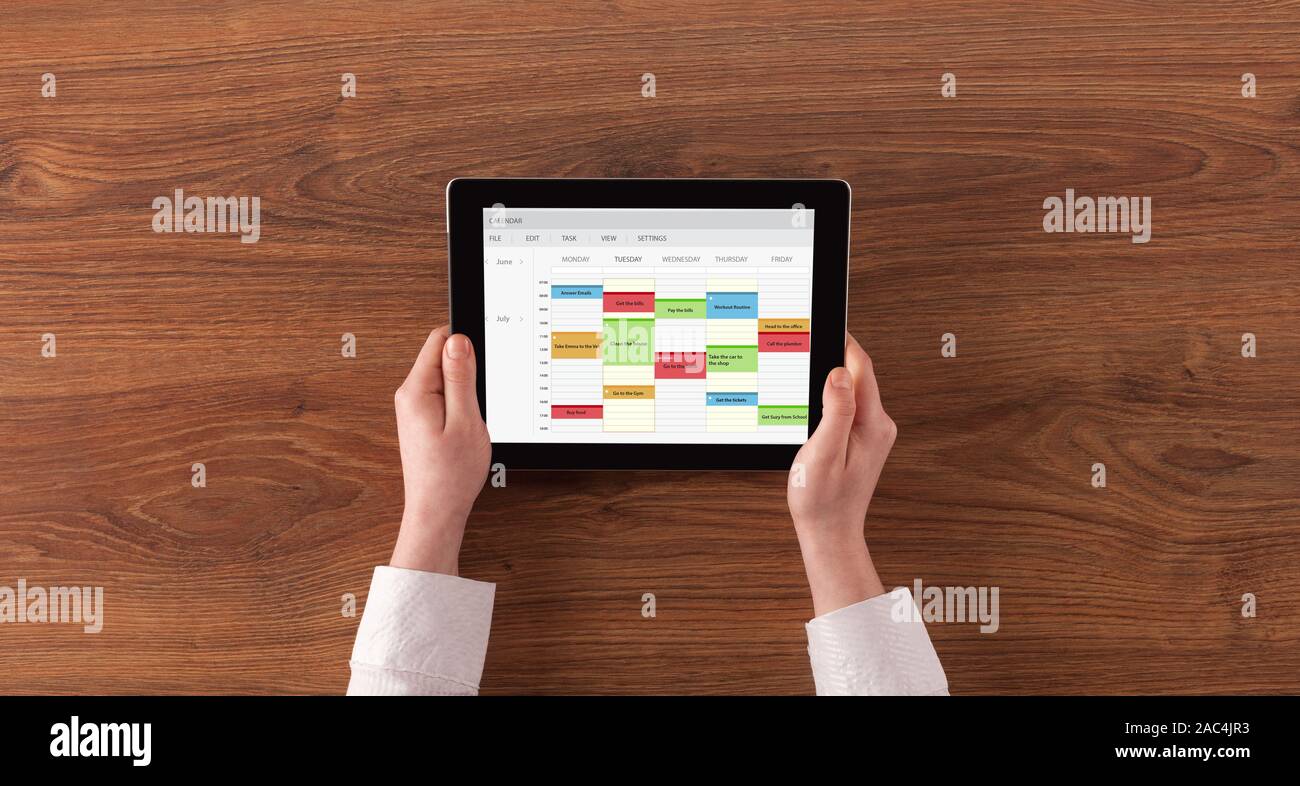 Hand holding tablet with timetable and calendar concept Stock Photo - Alamy