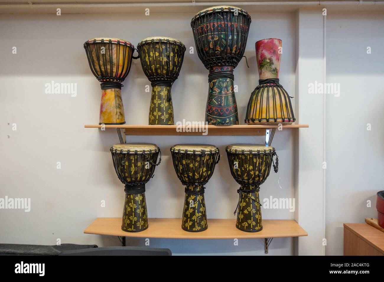 Djembe drums stored on shelves Stock Photo - Alamy