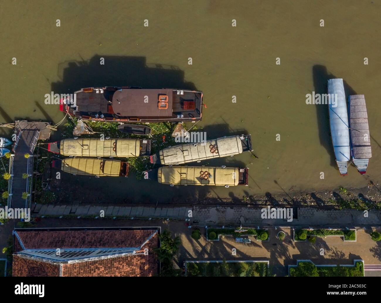 Late afternoon aerial view of river boats tied up on waterfront from ...