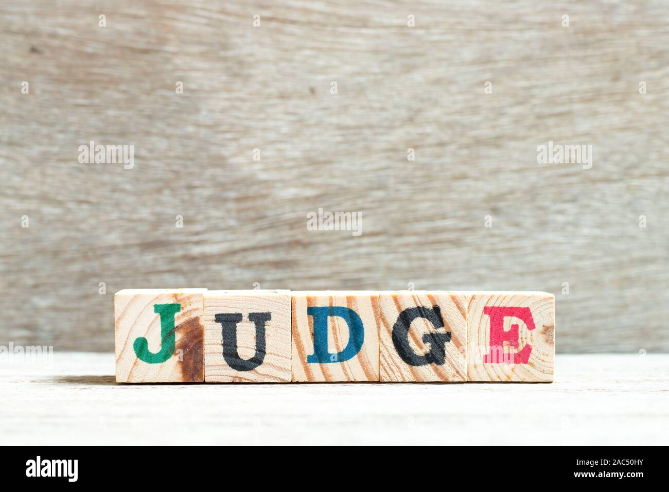 Letter block in word judge on wood background Stock Photo - Alamy