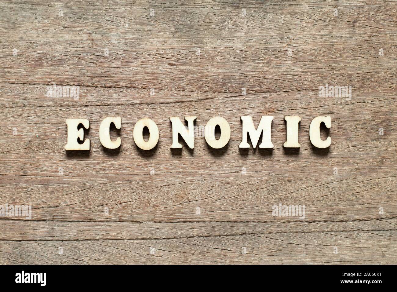 Letter block in word economic on wood background Stock Photo - Alamy
