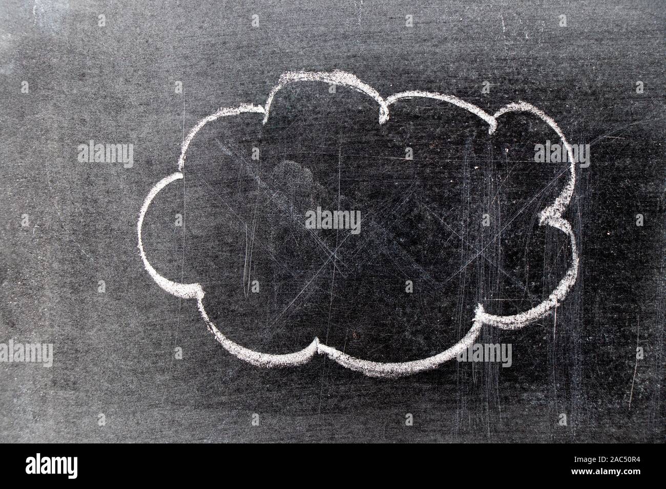 White color chalk hand drawing in cloud or blank speech bubble shape on ...