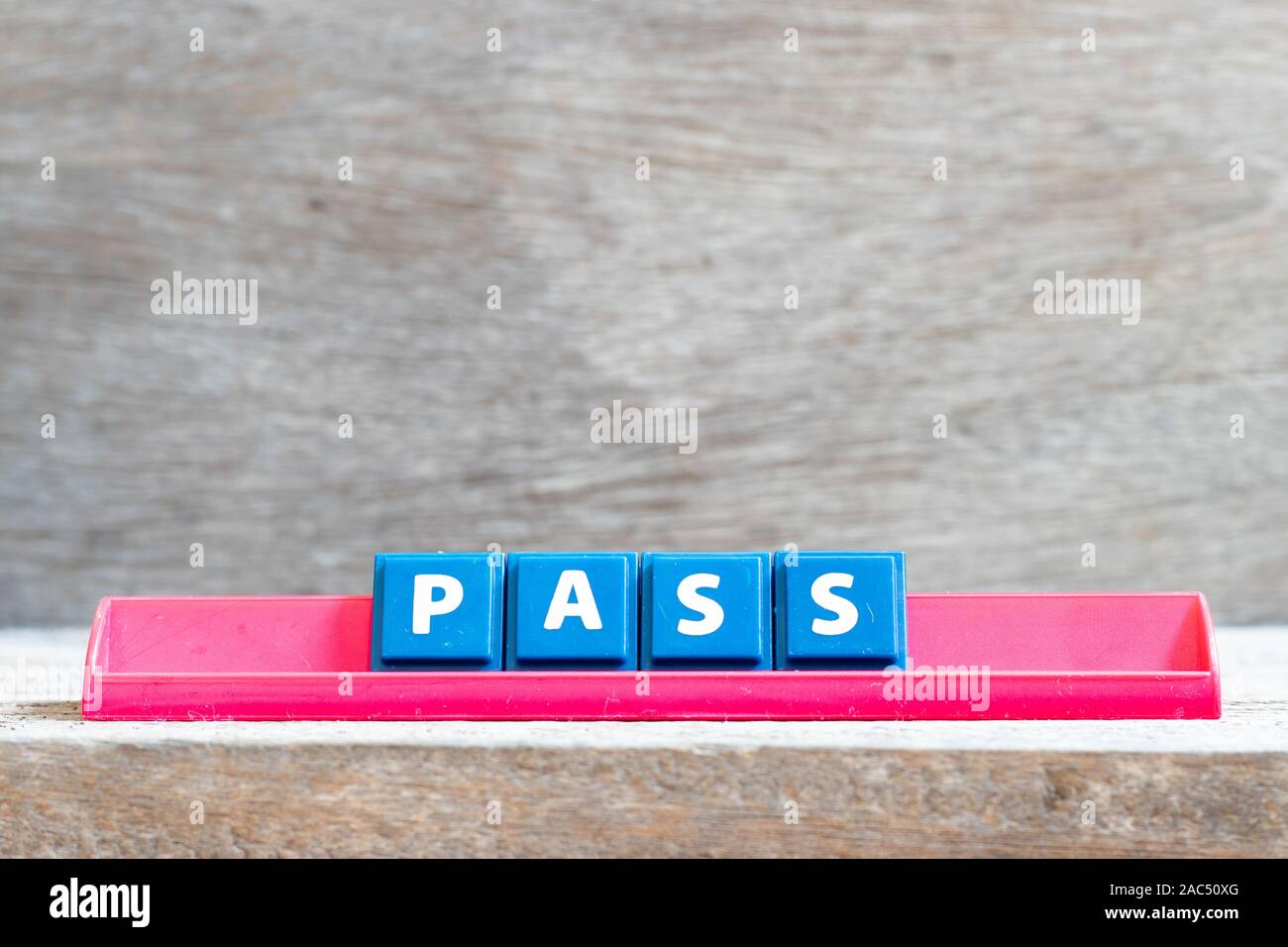 Tile letter on red rack in word pass on wood background Stock Photo - Alamy