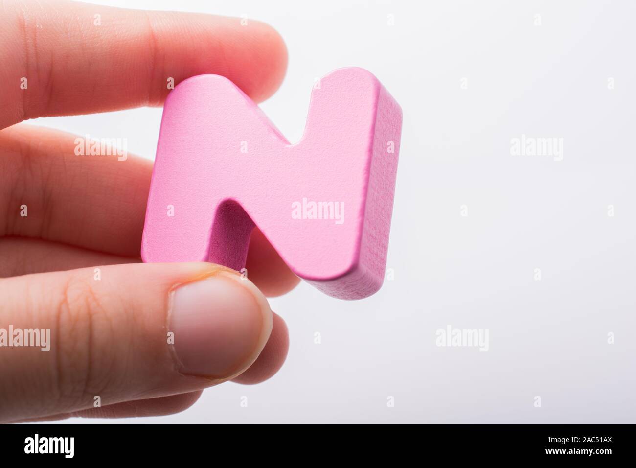 Hand holding letter cube N of made of wood Stock Photo - Alamy