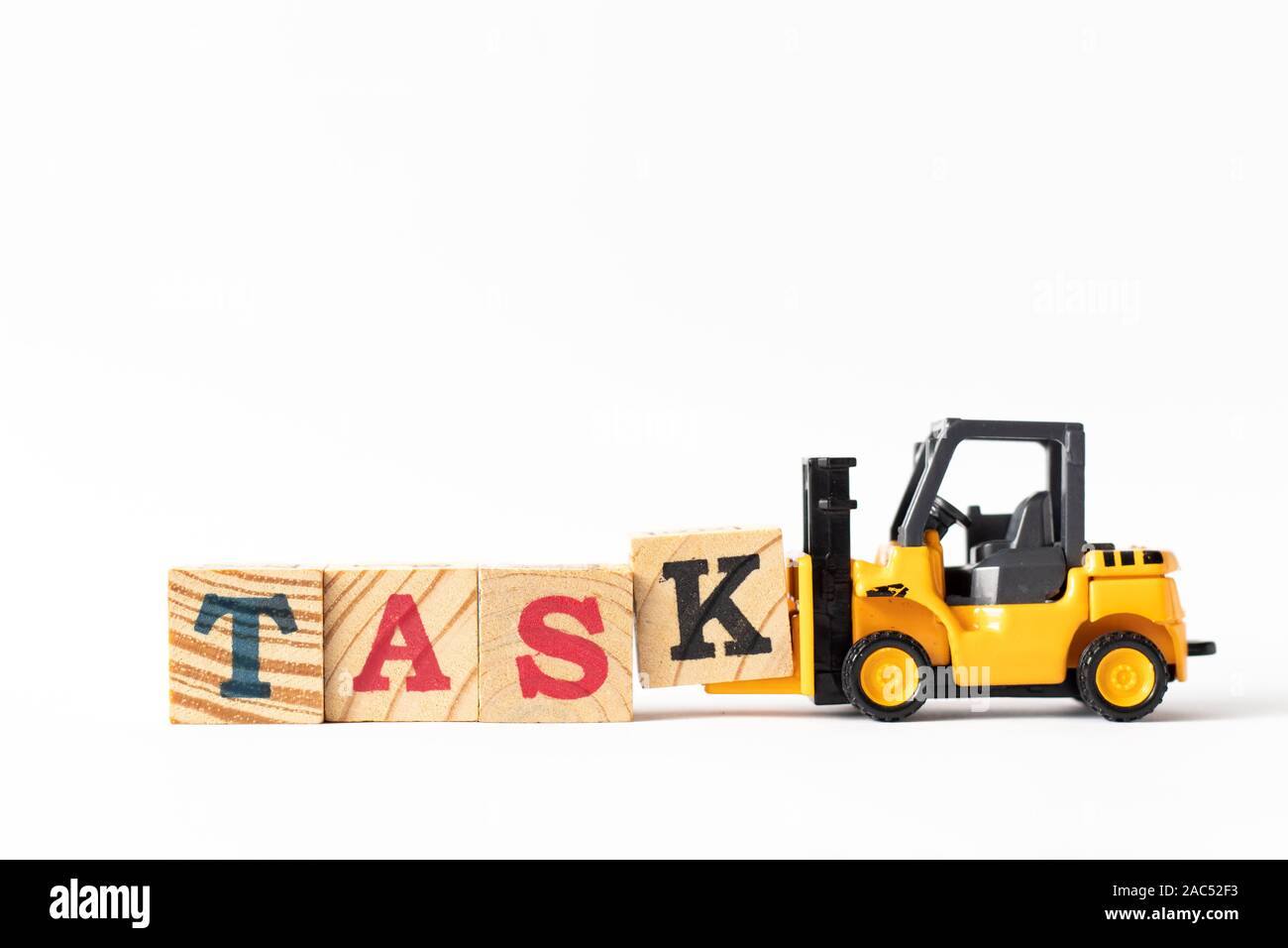 Toy forklift hold wood letter block k to complete word task on white ...