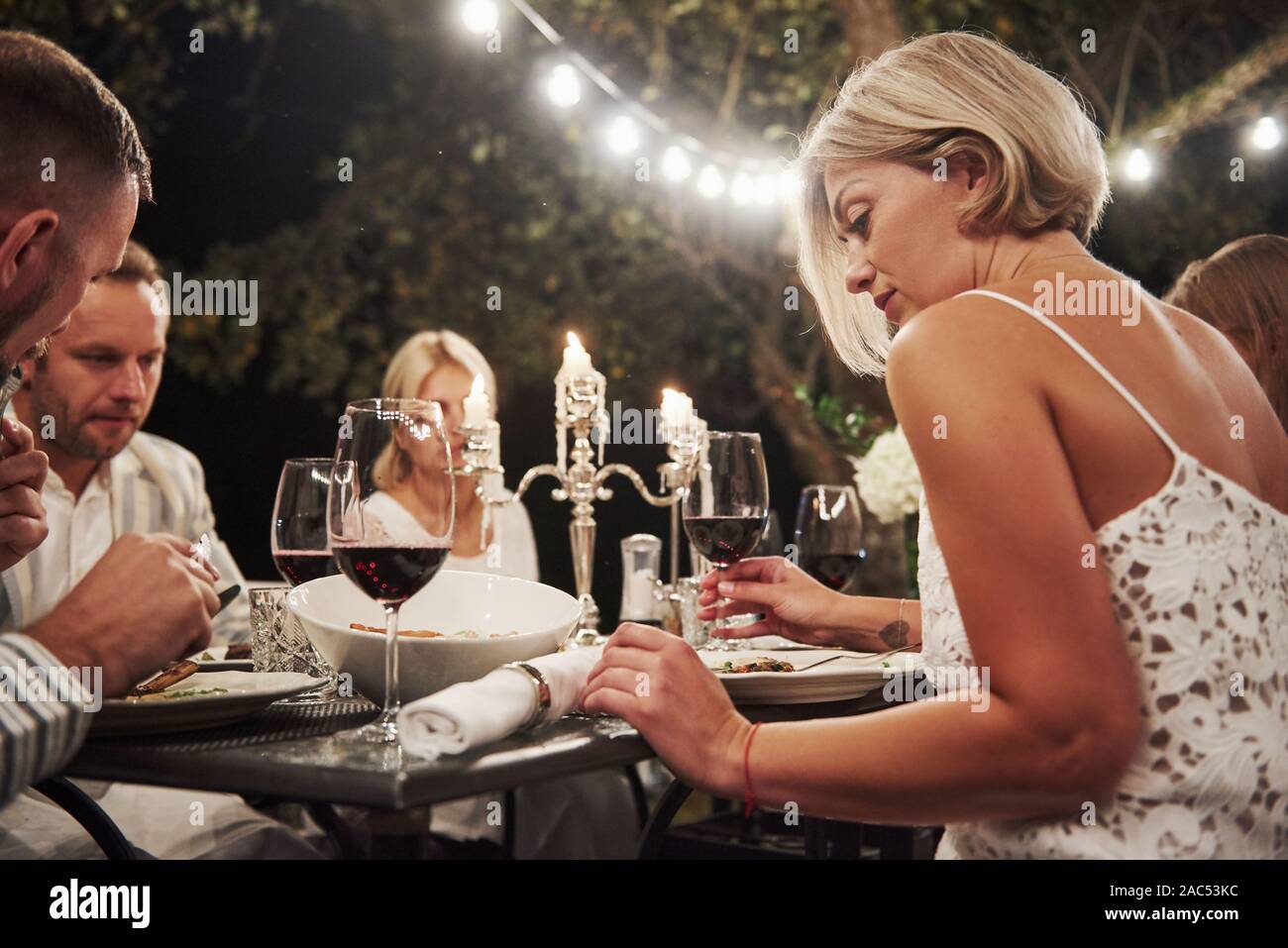 Side view. Friends have meeting at evening. Nice outside restaurant ...